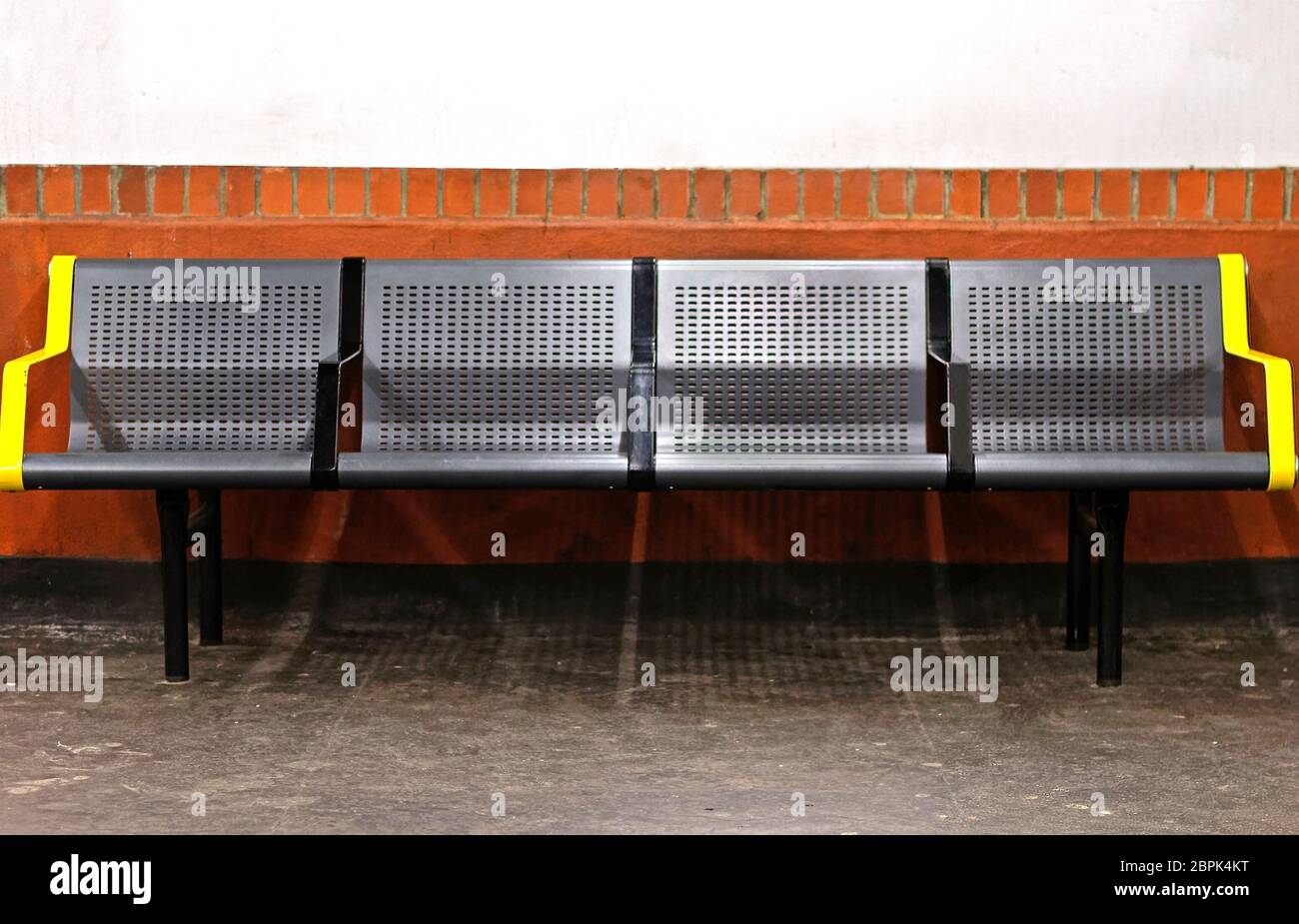 Metal seats inside metro station for people to wait for a train on a ...