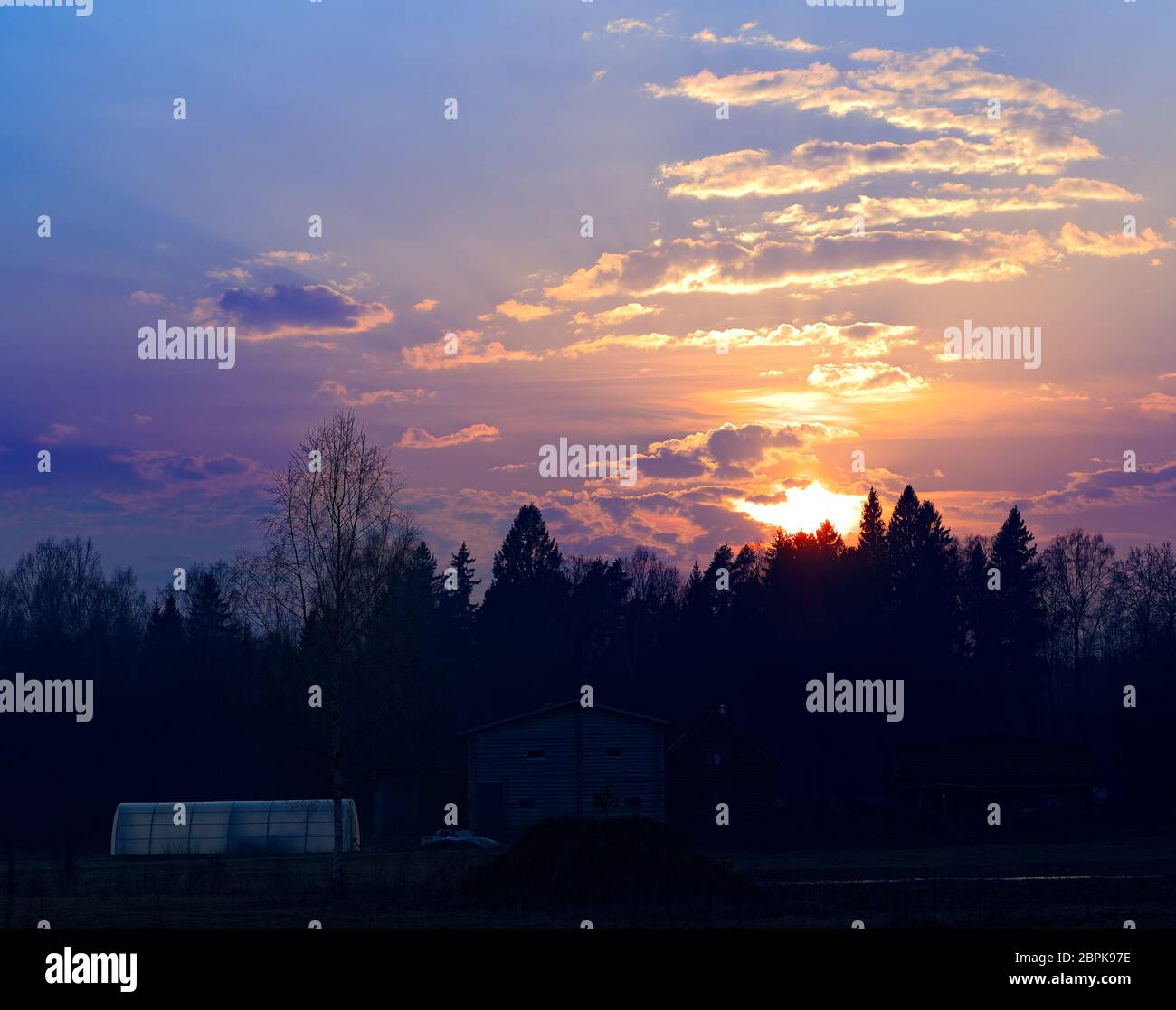 Burning sunset at village farm background Stock Photo - Alamy