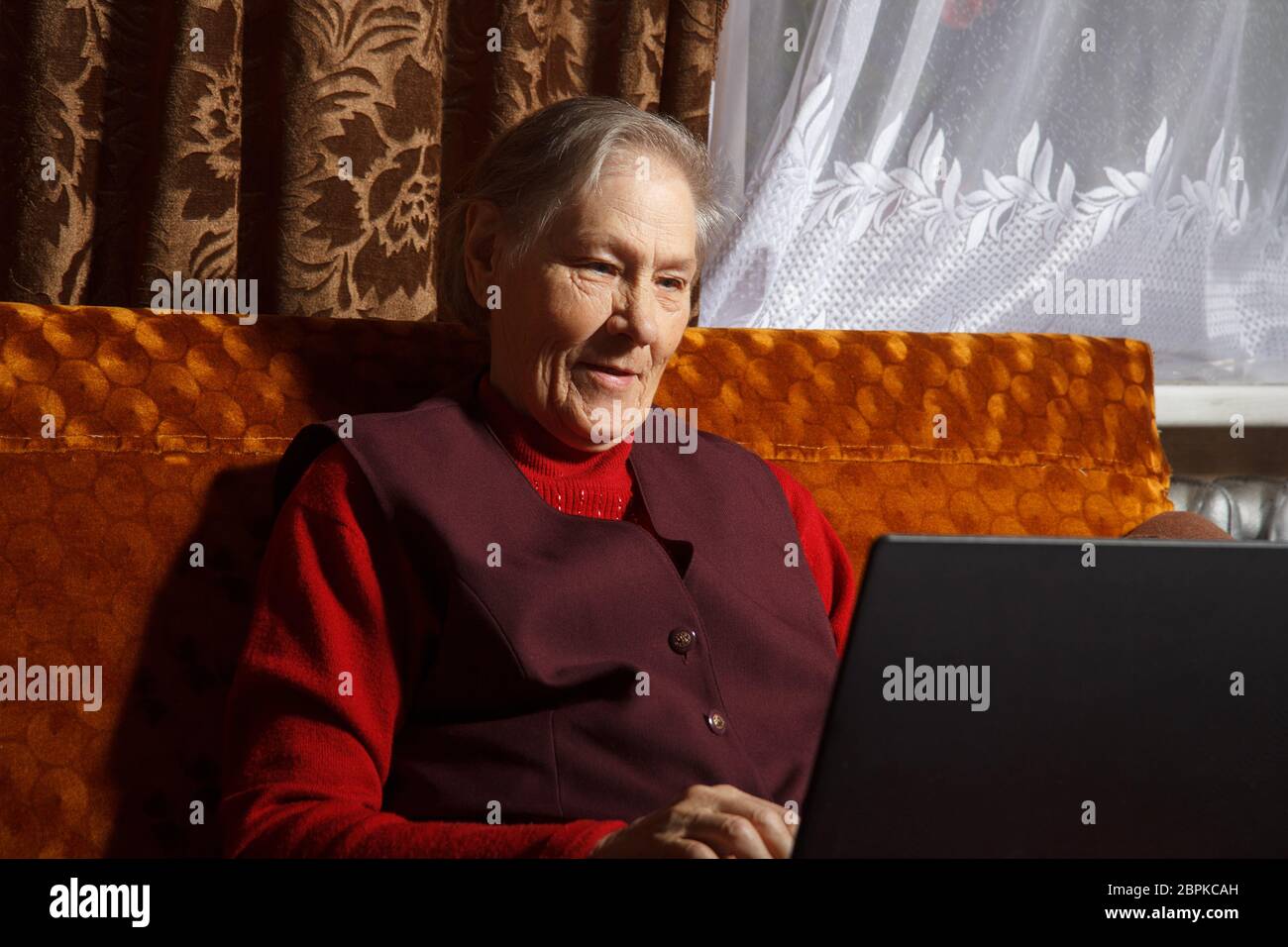very old woman using laptop sitting in her sofa Stock Photo - Alamy