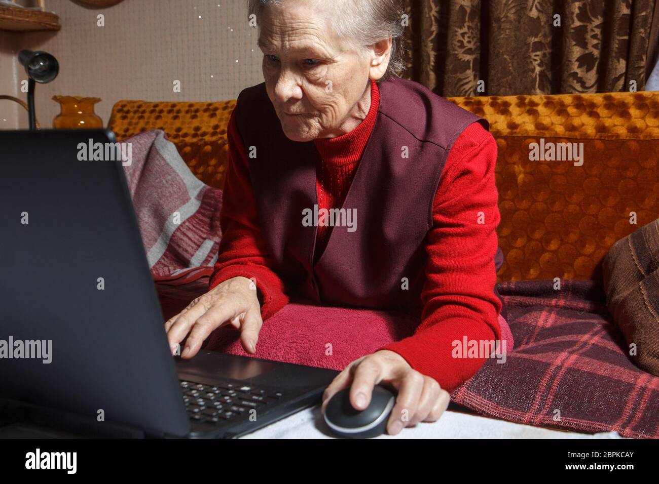very old woman using laptop sitting in her sofa Stock Photo - Alamy