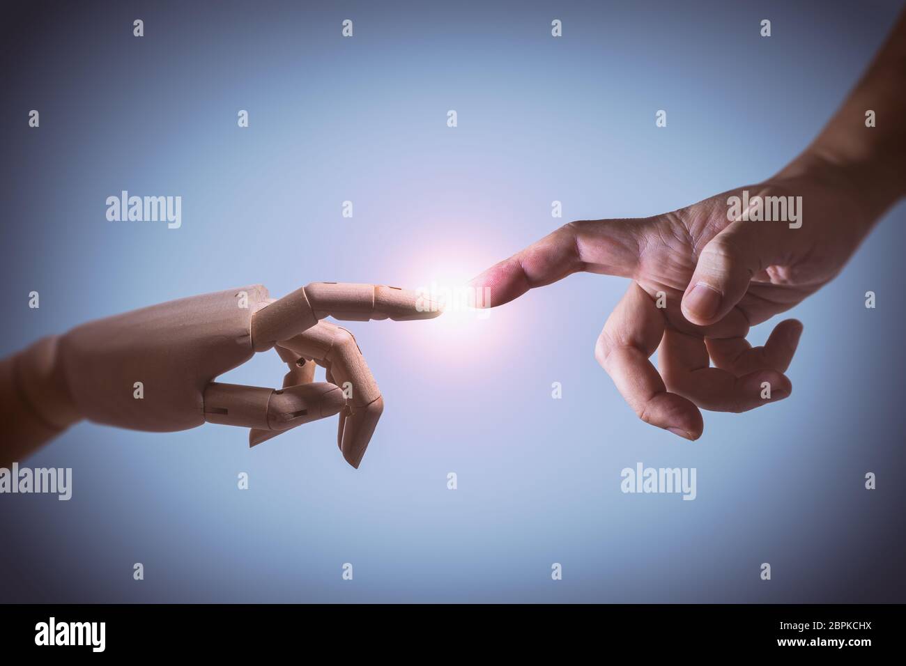 Photograph of a human hand and a hinged wooden hand. Concept image of ...