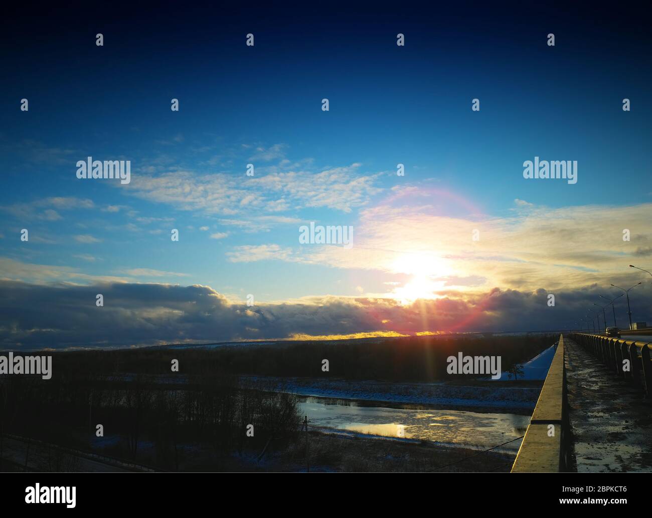 Cloudy sunset on the river bridge nature background Stock Photo - Alamy