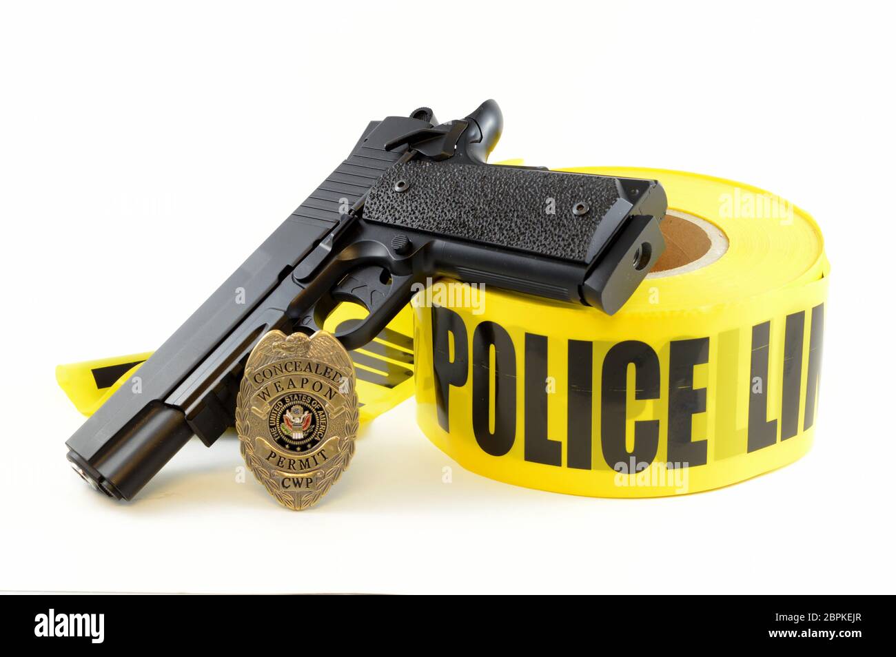 Closeup view of a handgun with a weapons badge and some police tape for ...