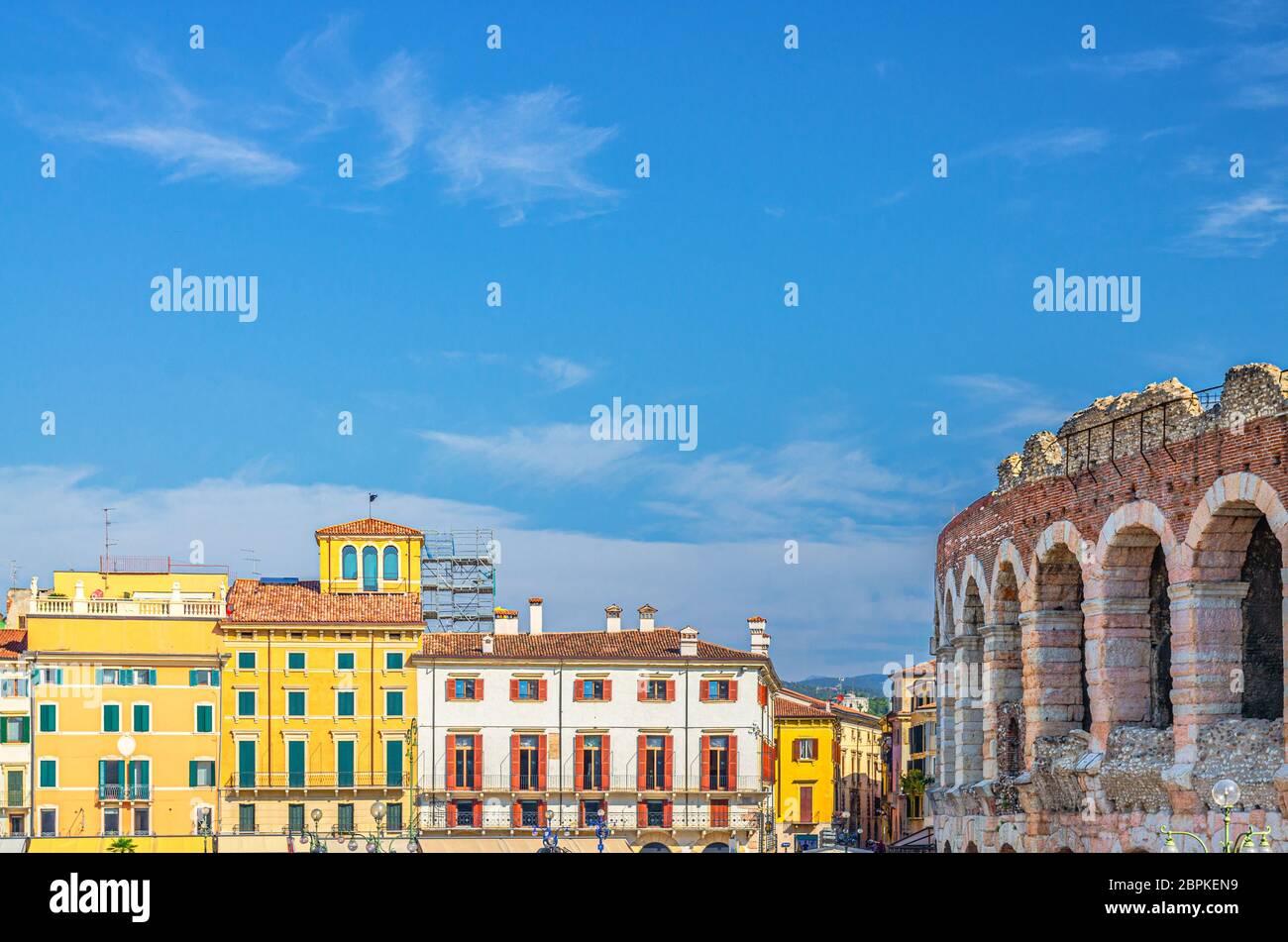 The Verona Arena limestone walls with arch windows and old colorful ...
