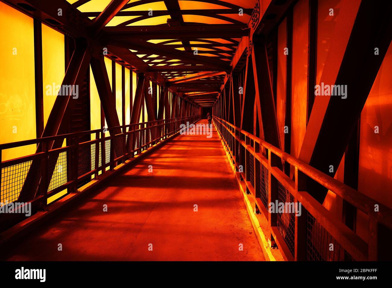 Man crossing city bridge during sunset time background Stock Photo - Alamy