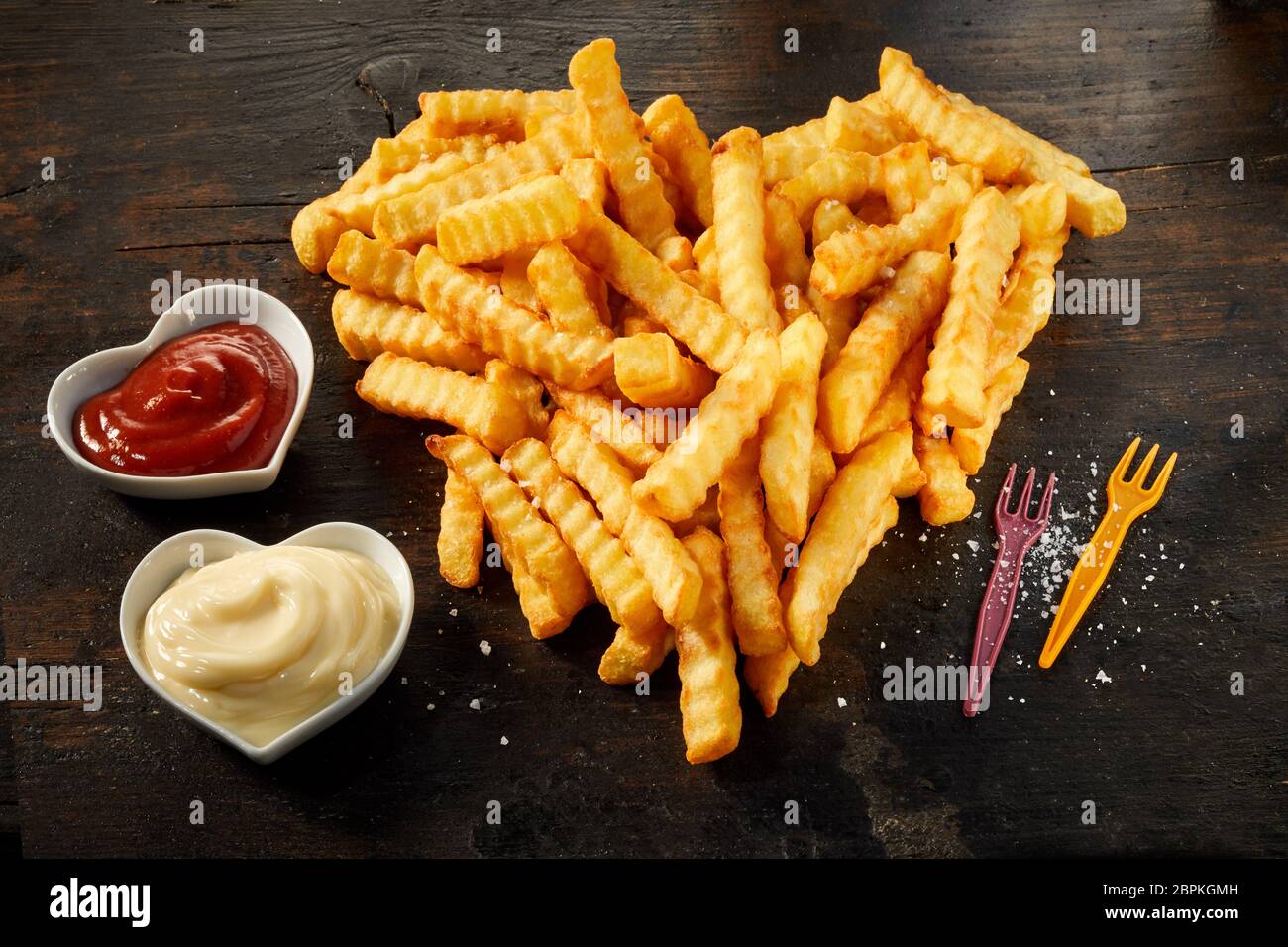 Oven baked crispy crinkle cut Pommes Frites arranged in a heart shape ...