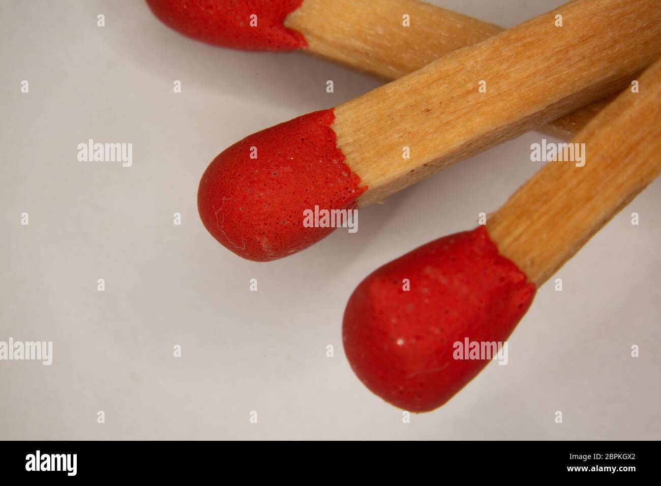 Matchstick with red head under the magnifying glass Stock Photo - Alamy