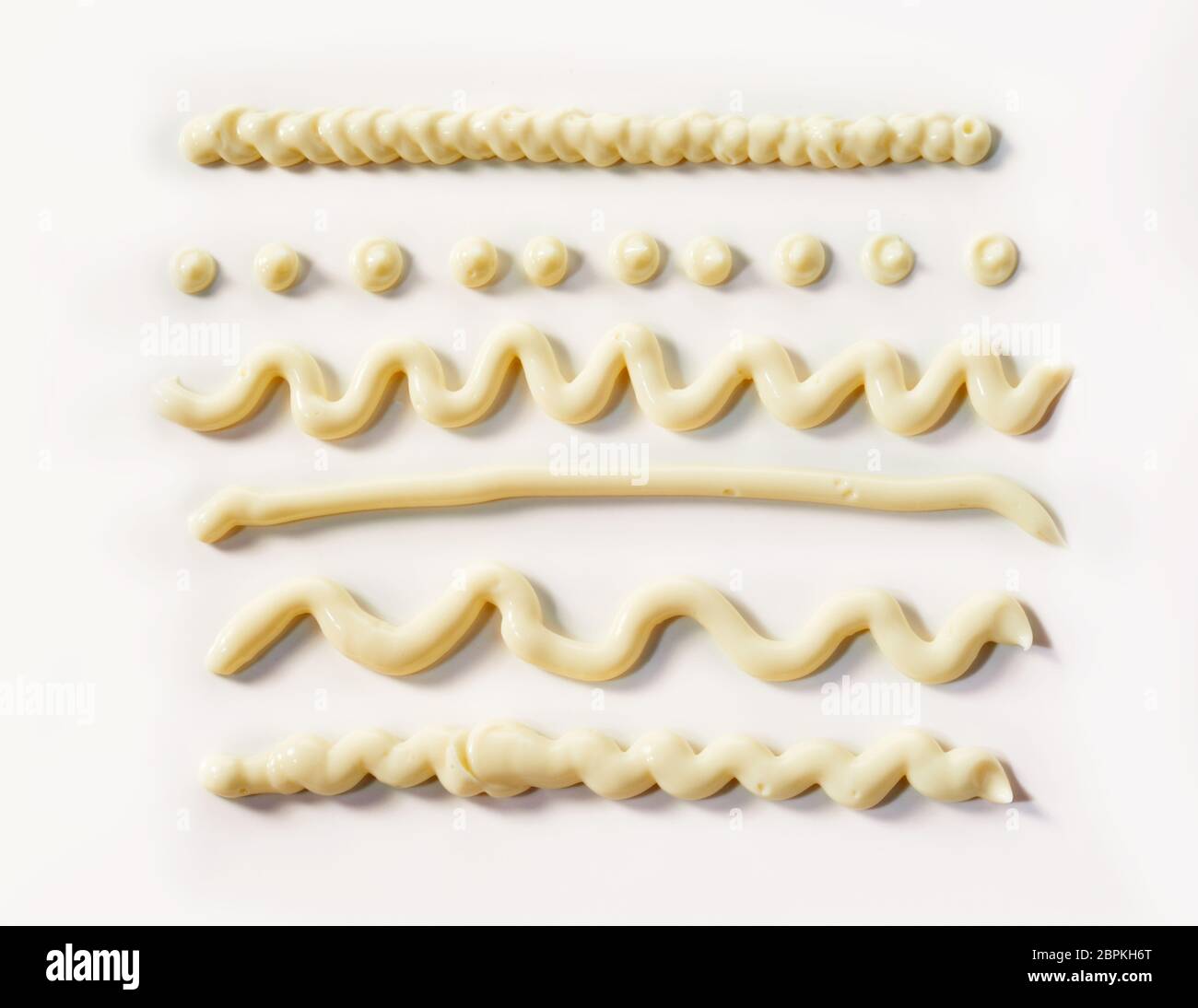 Decorative wavy lines and dots of mayonnaise piped from a tube on a ...