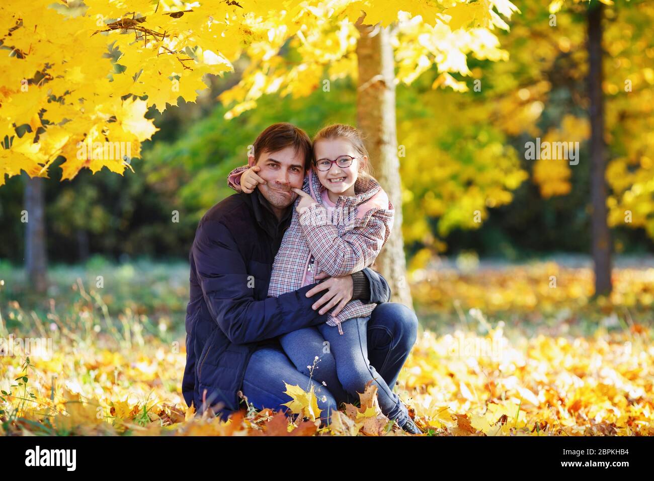 Dad with daughter in the park in the fall. Happy family. Sunny autumn ...