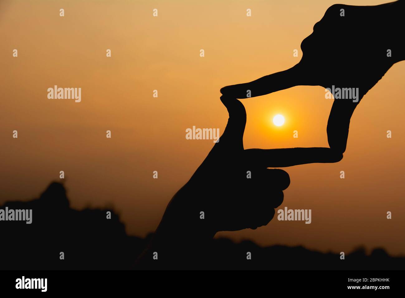 Hands making frame with sunset. Close up of woman hands making frame ...