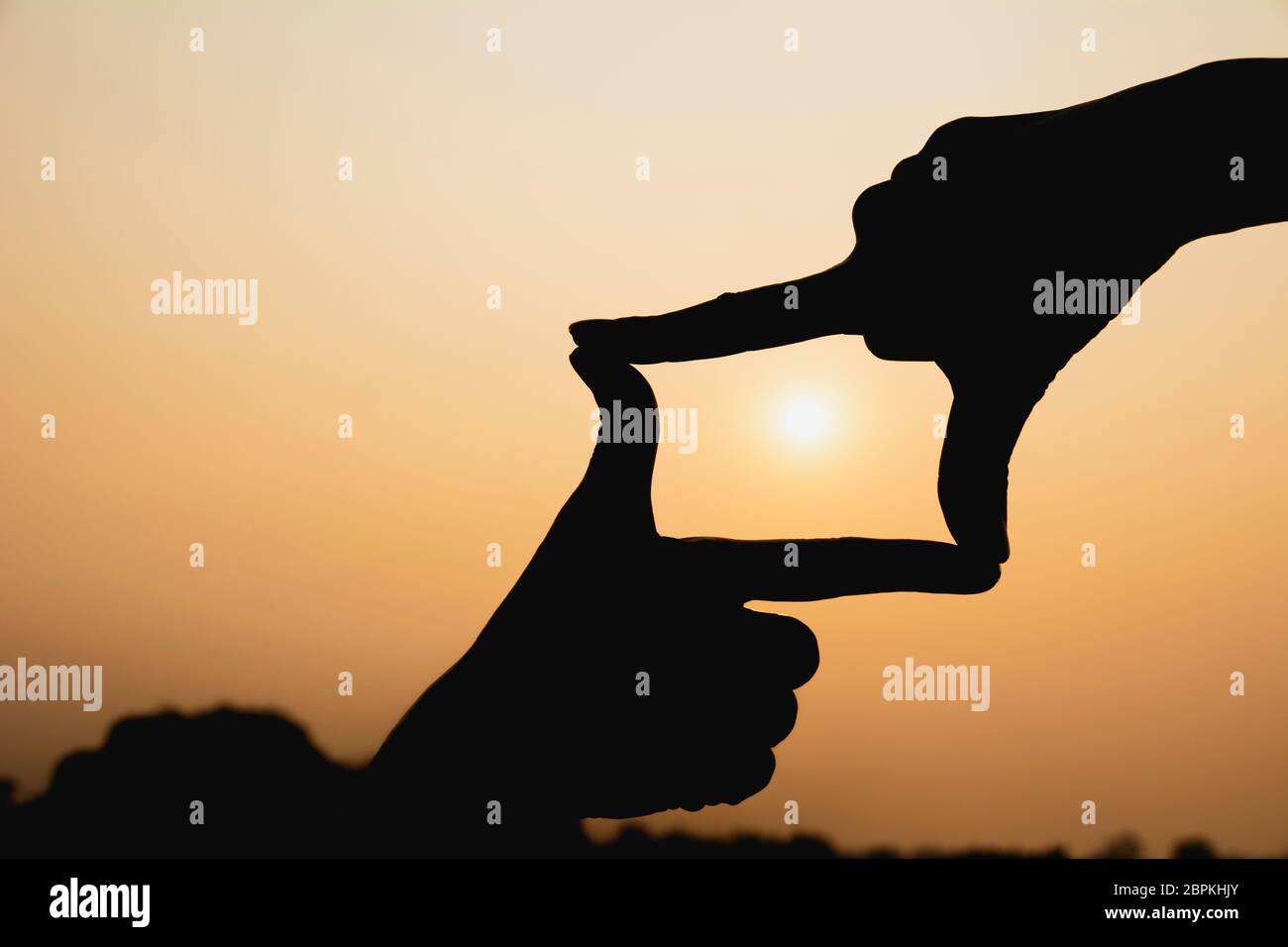 Hands making frame with sunset. Close up of woman hands making frame ...