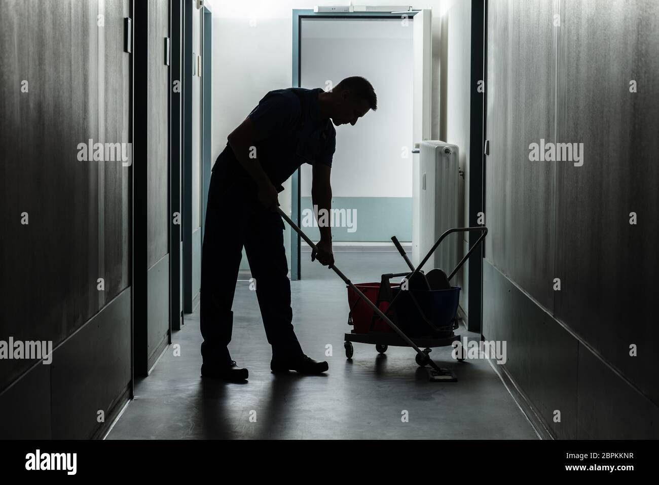 Silhouette Of A Male Janitor Cleaning Corridor Stock Photo - Alamy