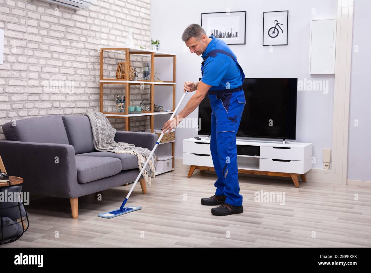 Mature Male Janitor Cleaning Floor With Mop At Home Stock Photo - Alamy