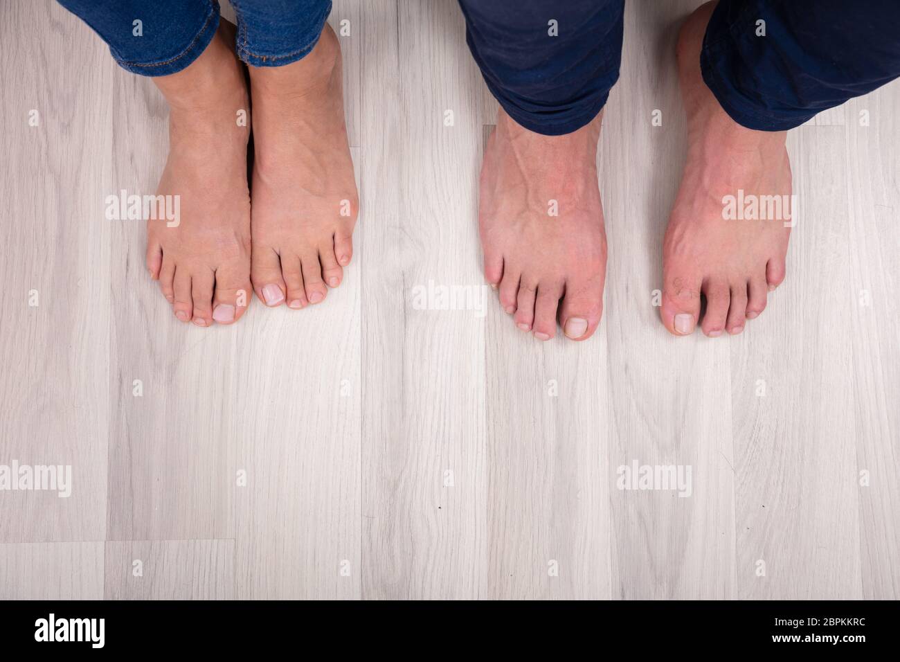 Low Section Of Couple's Feet On Floor In Living Room Stock Photo - Alamy