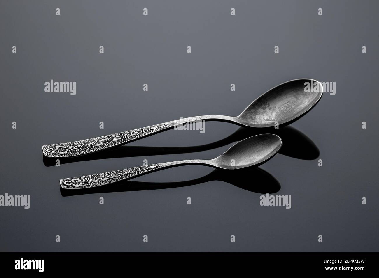 Old nickel silver spoons on a reflective surface Stock Photo - Alamy