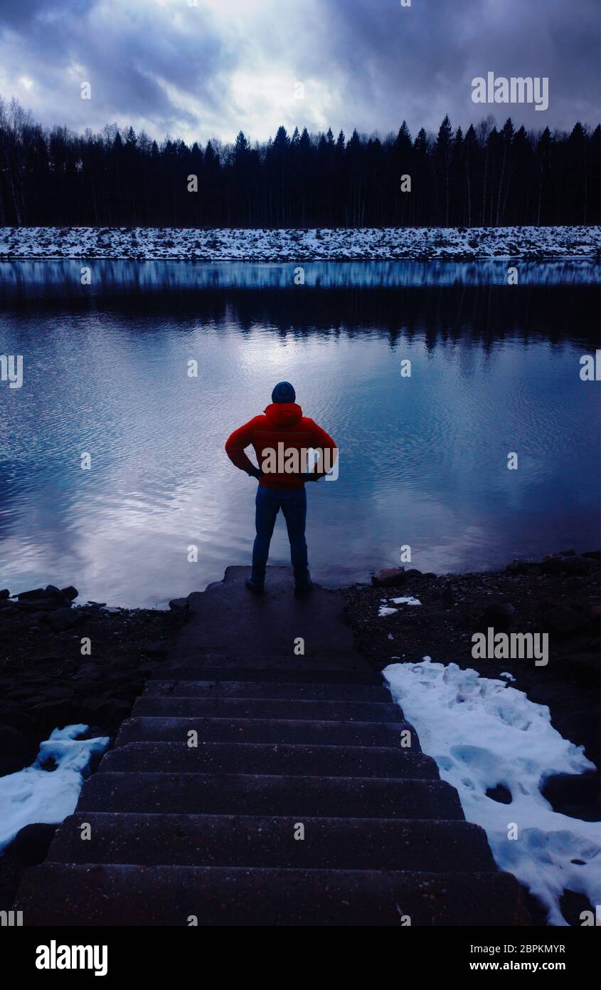 Explorer with akimbo hands staring at spring river Stock Photo - Alamy
