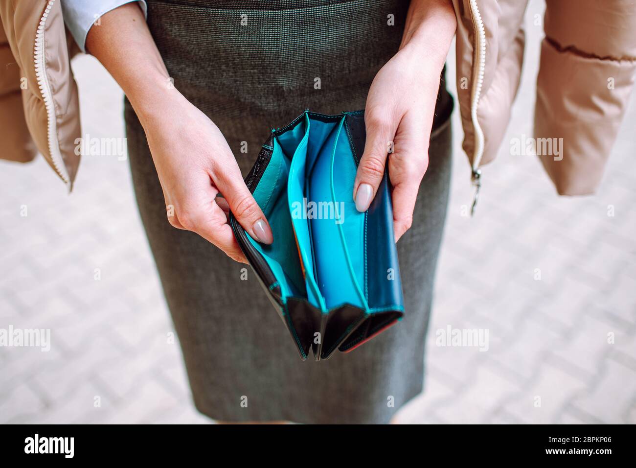 Woman wearing office suit holding open empty wallet. Unemployment, low ...