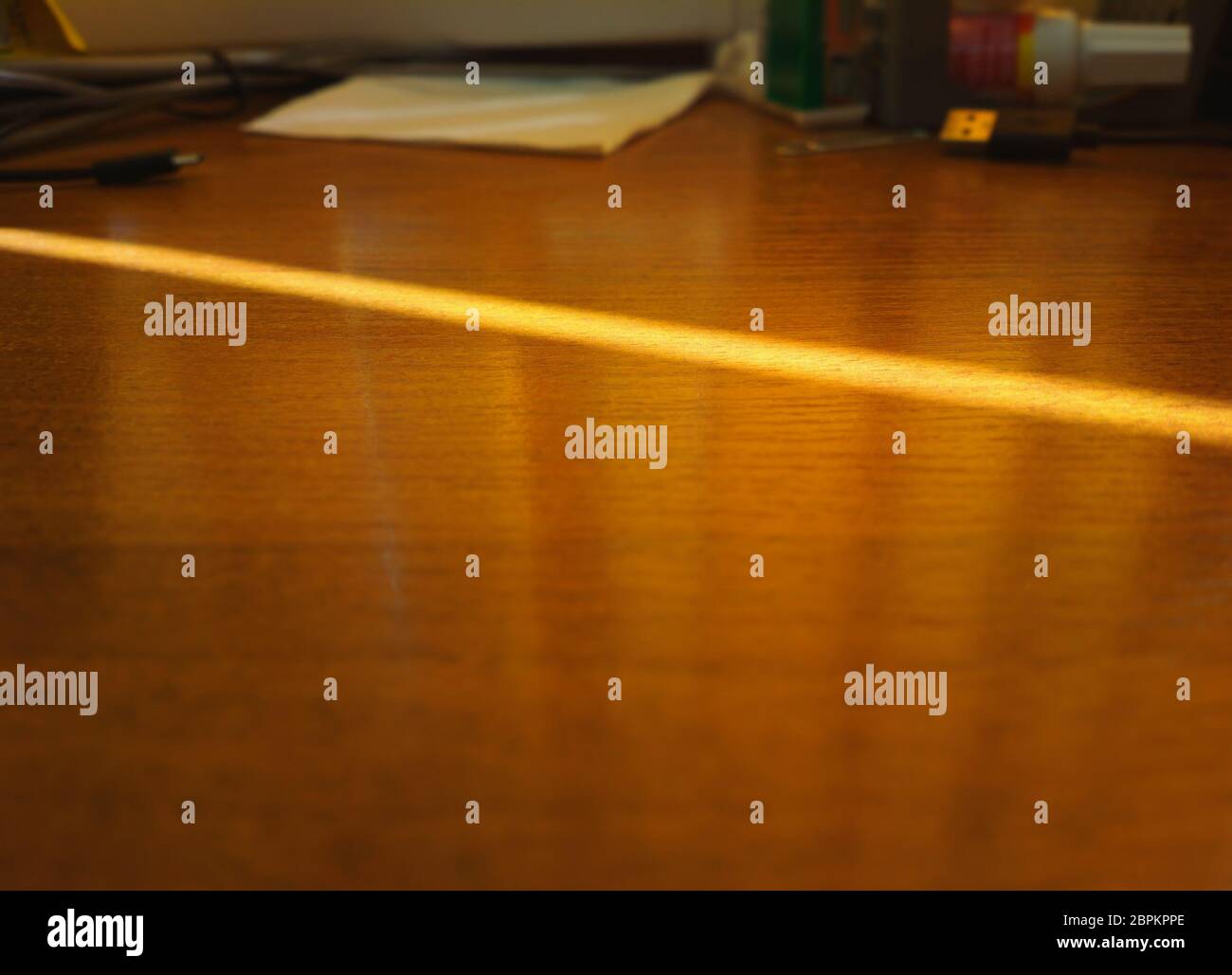 Diagonal light ray on office wooden table background Stock Photo - Alamy