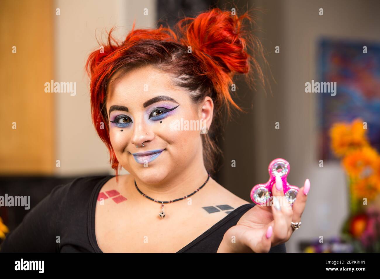 Girl spinning a fidget spinner while smiling Stock Photo - Alamy