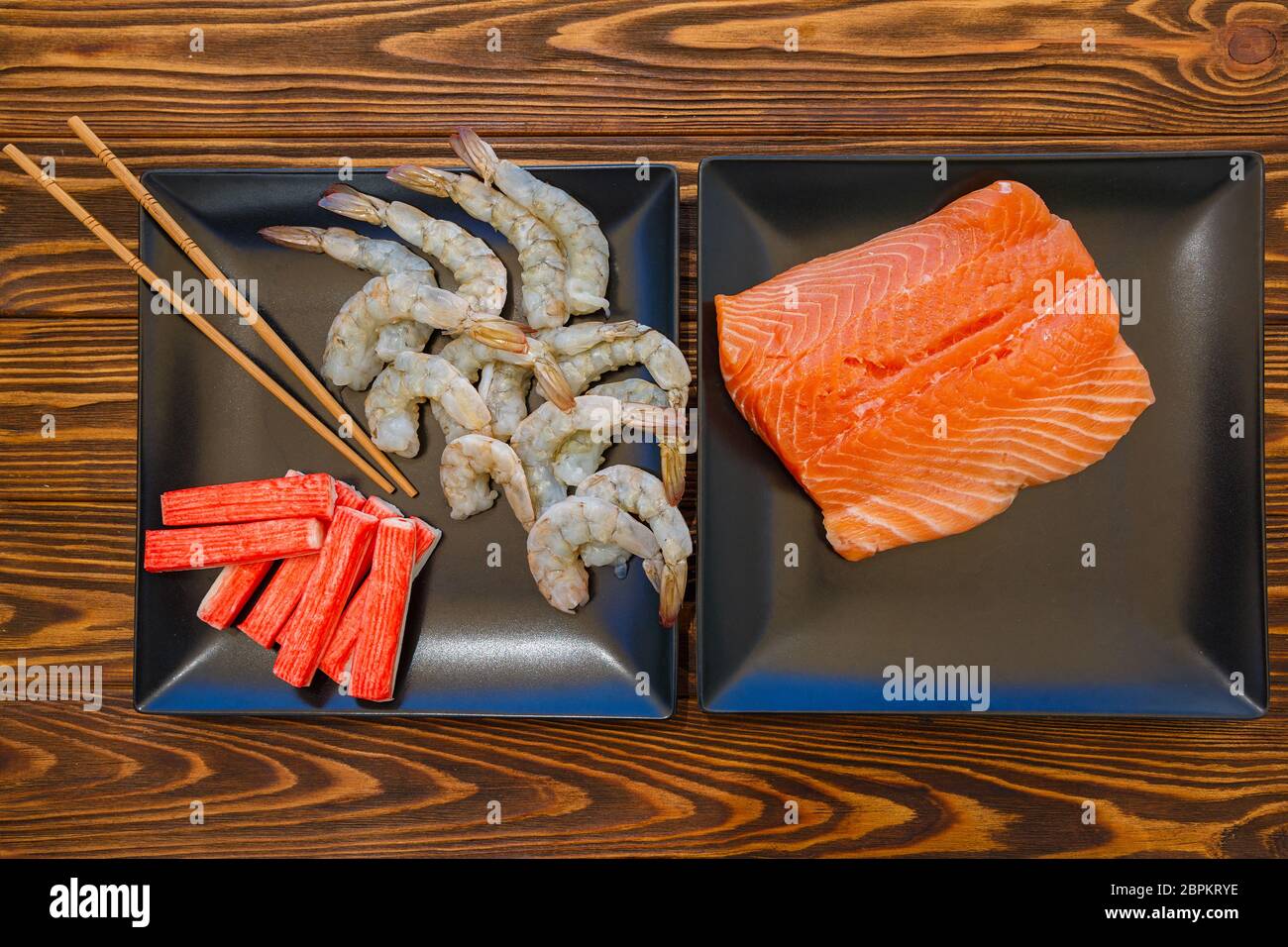 Red fish fillets, prawns and crab sticks on a wooden background Stock ...