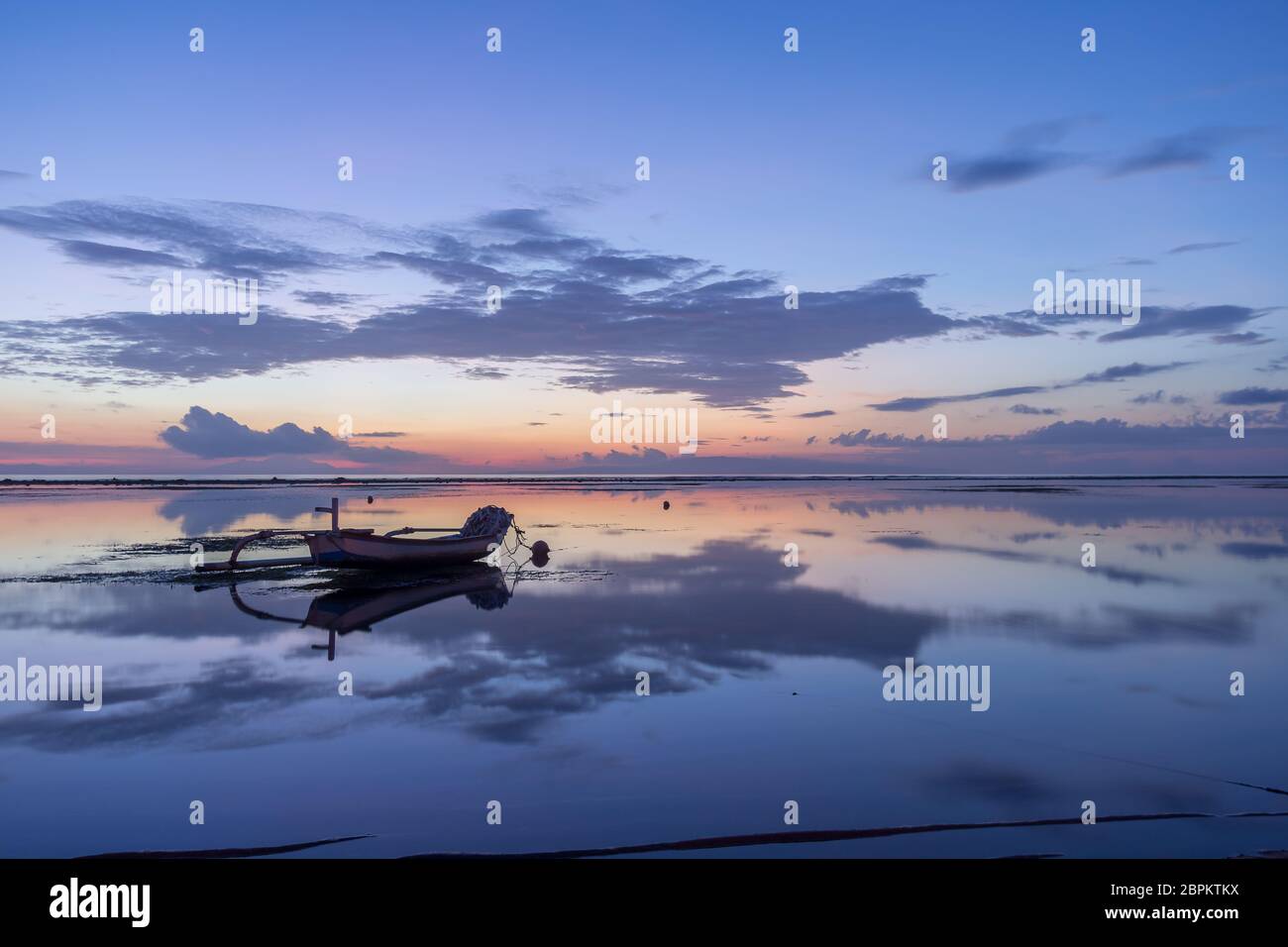 traditional indonesian fishing boat in blue twilight, loaded with a ...