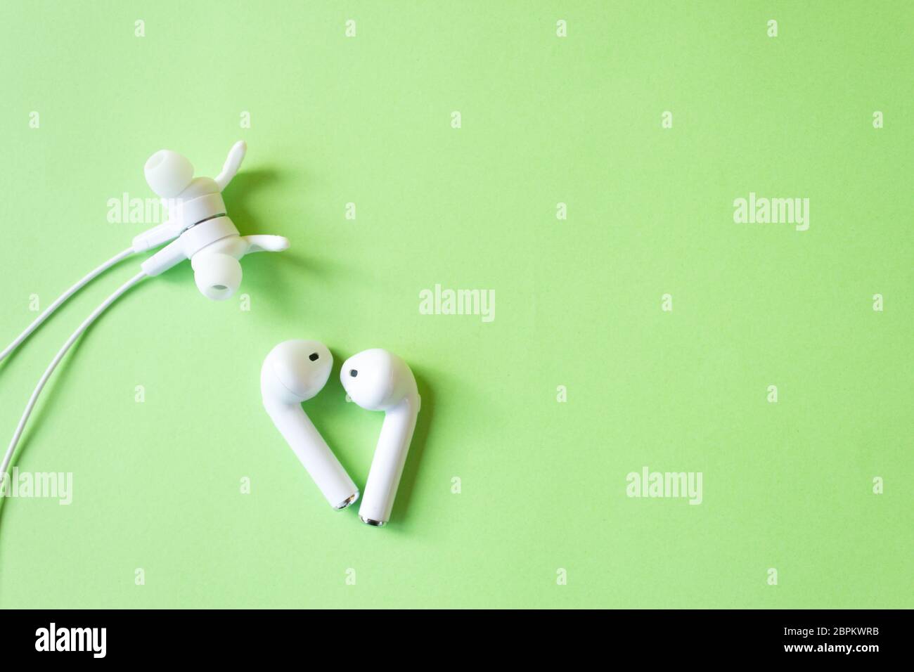 White headphones with a wire on a yellow background. The concept of ...