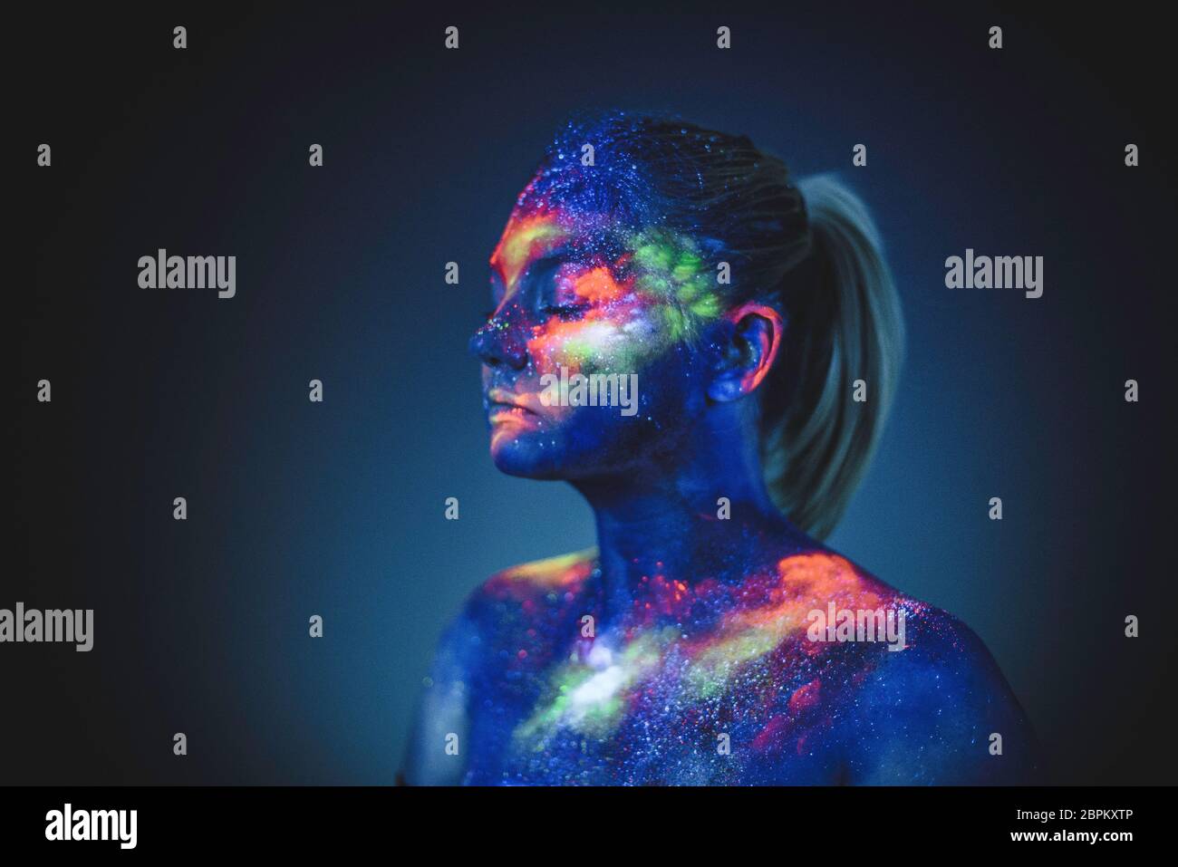 Conceptual shot of light and shine fluorescent colors young girl's face ...