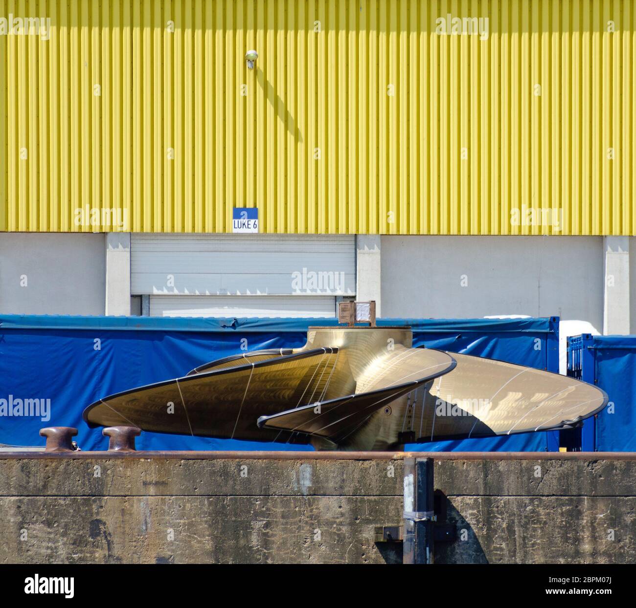 New purpose-built gold coloured screw propeller for a big cargo ship ...