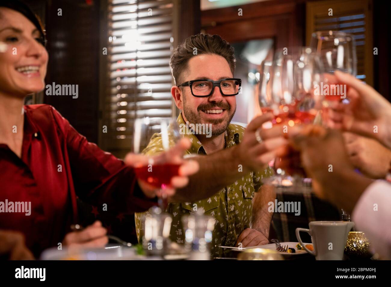 Cheerful mature man raising his glass for a celebratory toast with her ...