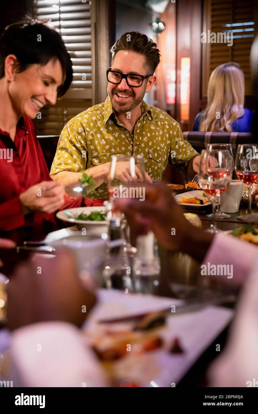 Friends catching up over a meal in a restaurant. They are smiling and ...