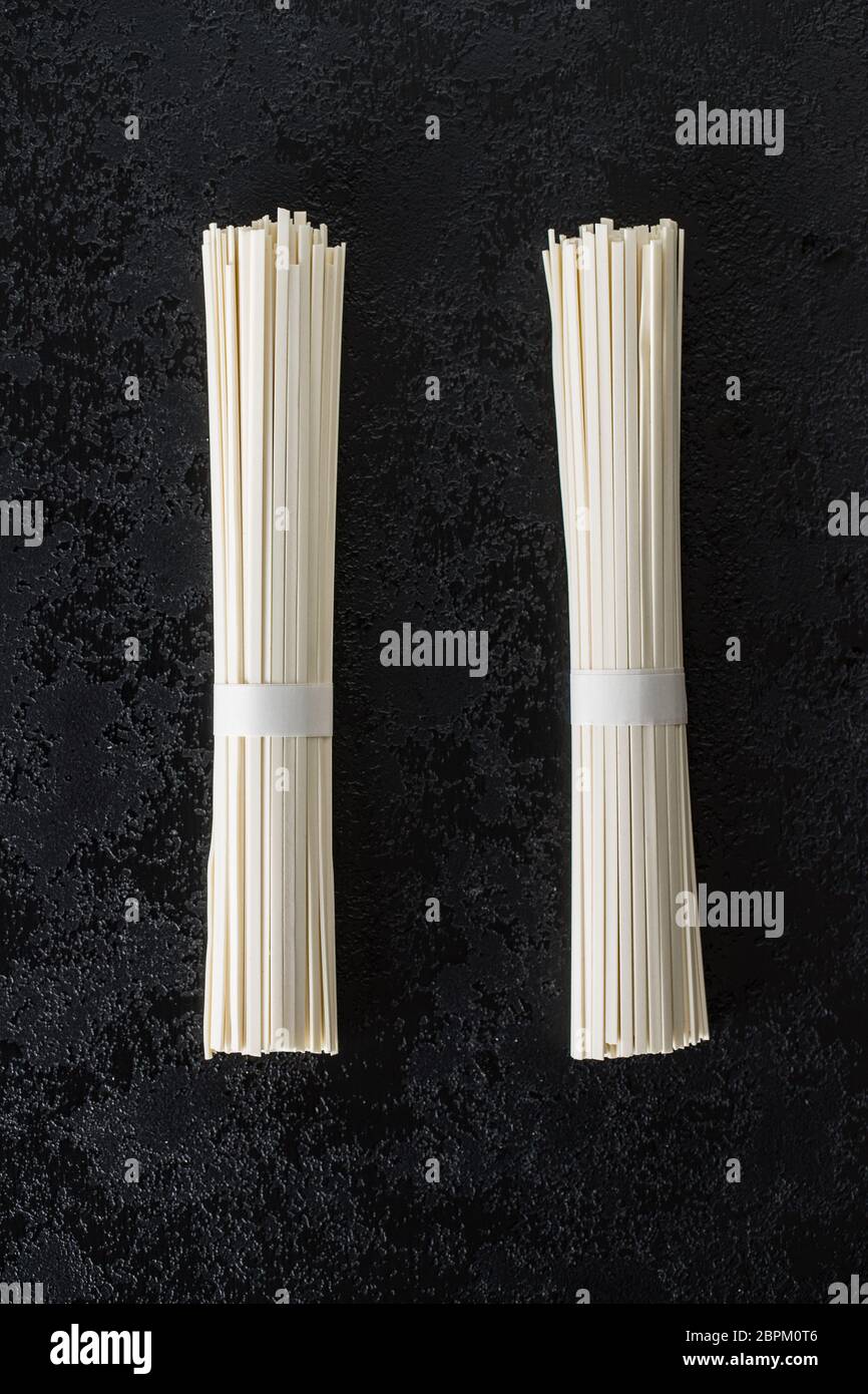 Raw udon noodles on black table. Top view Stock Photo - Alamy