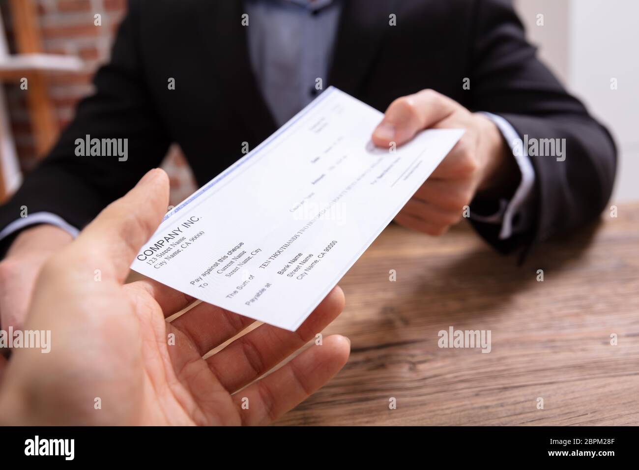 Close-up Of Businessman's Hands Giving Cheque To Other Person In Office ...