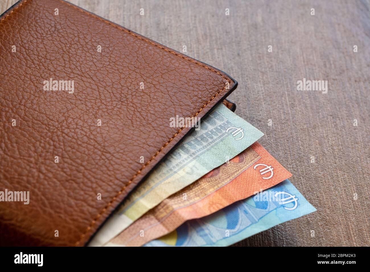 New leather wallet with euro money on a wooden background Stock Photo ...