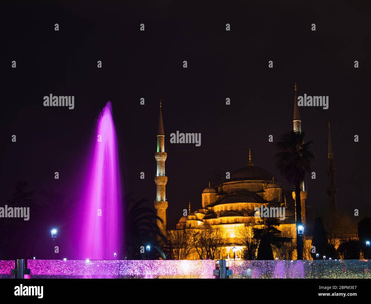 A colourful fountain in front of an illuminated mosque in Istanbul ...