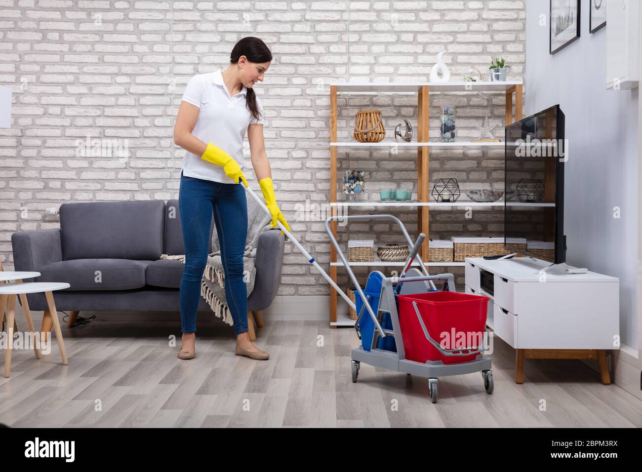 Female Janitor Cleaning Floor With Mop In Living Room Stock Photo - Alamy