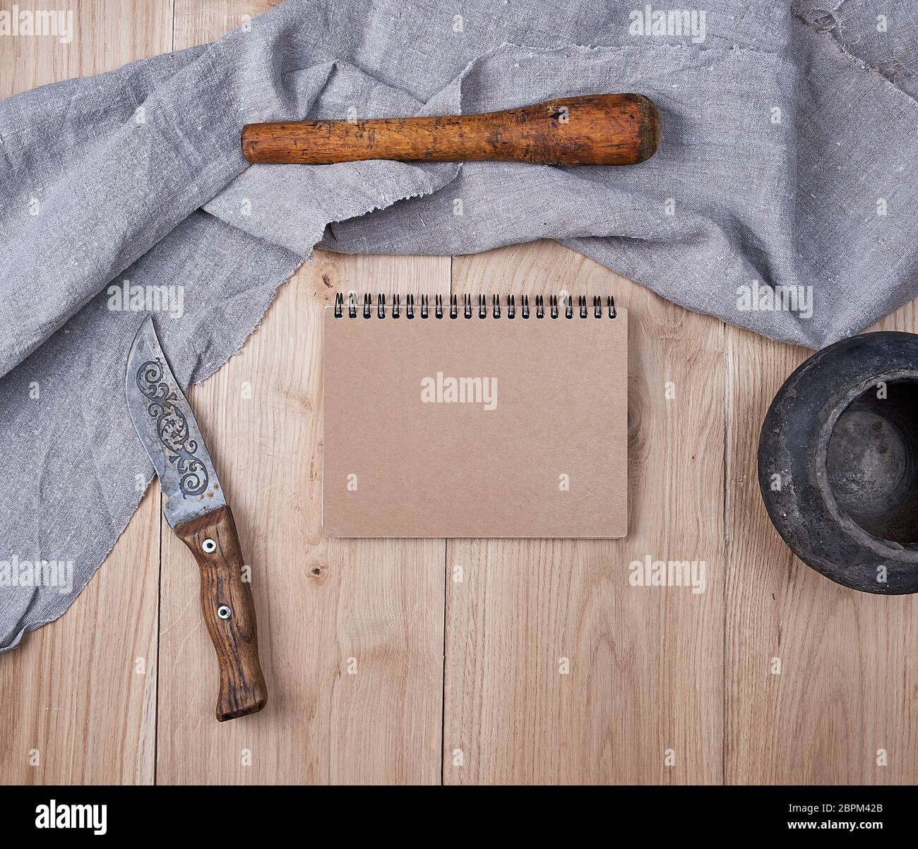 open empty notebook with brown sheets and a kitchen knife on the table ...