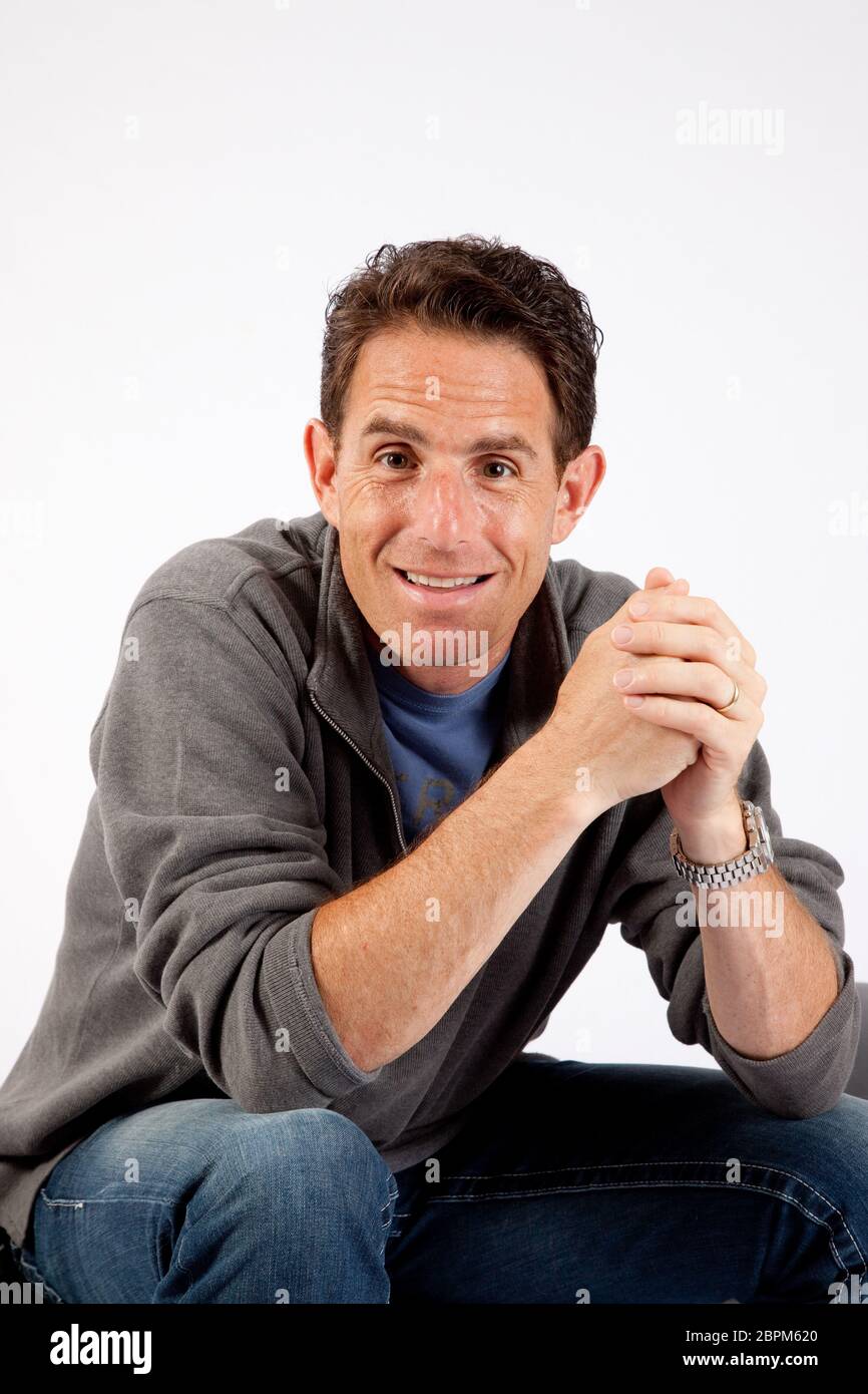 Happy man sitting with a smile Stock Photo - Alamy