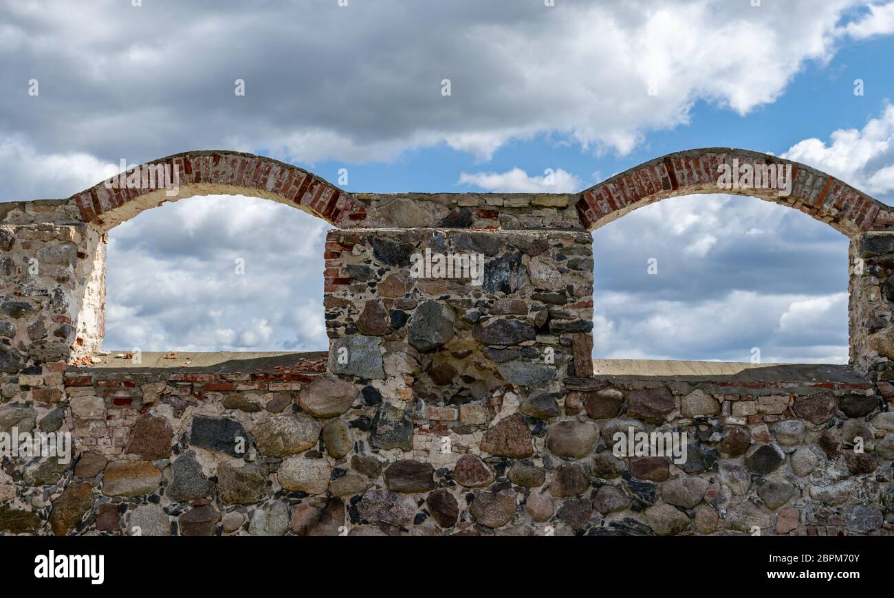spring landscape with an old stone building wall and arched windows ...