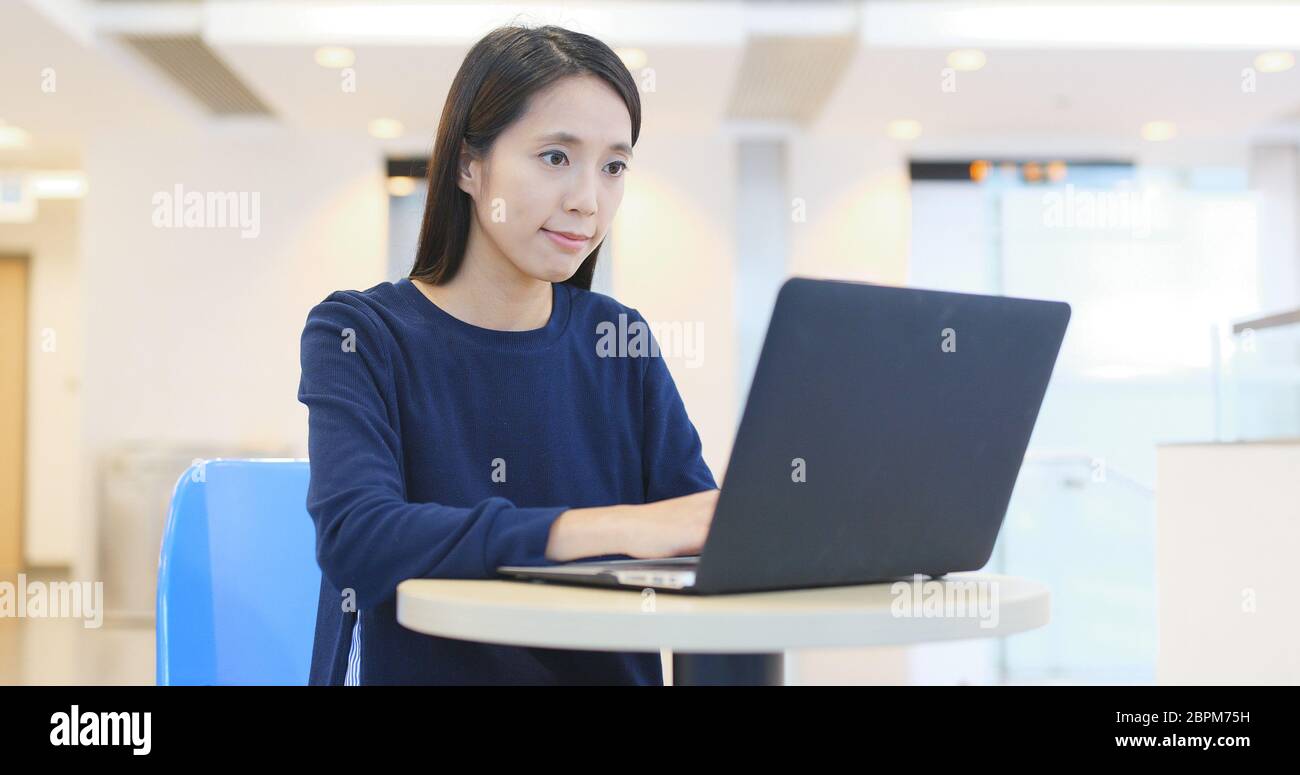Woman doing homework on laptop computer inside university campus Stock ...