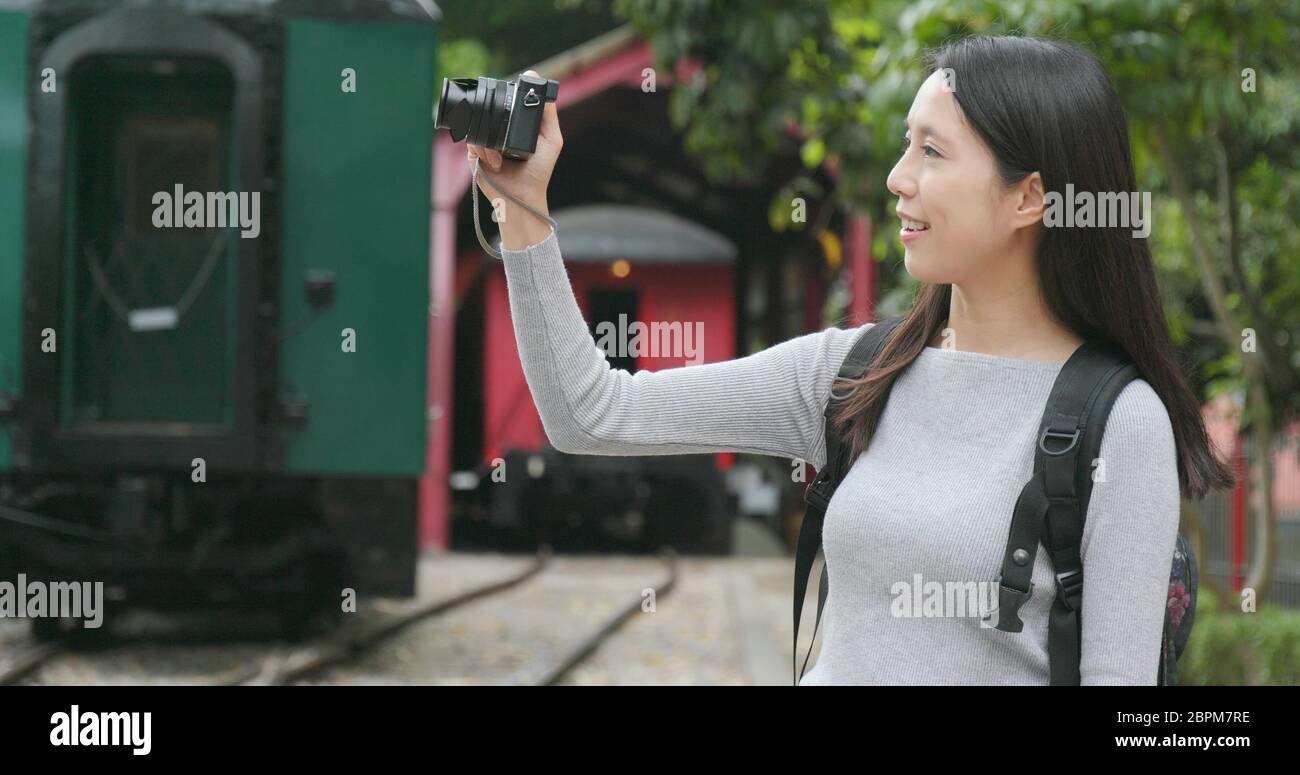 Travel woman taking photo on train station Stock Photo - Alamy