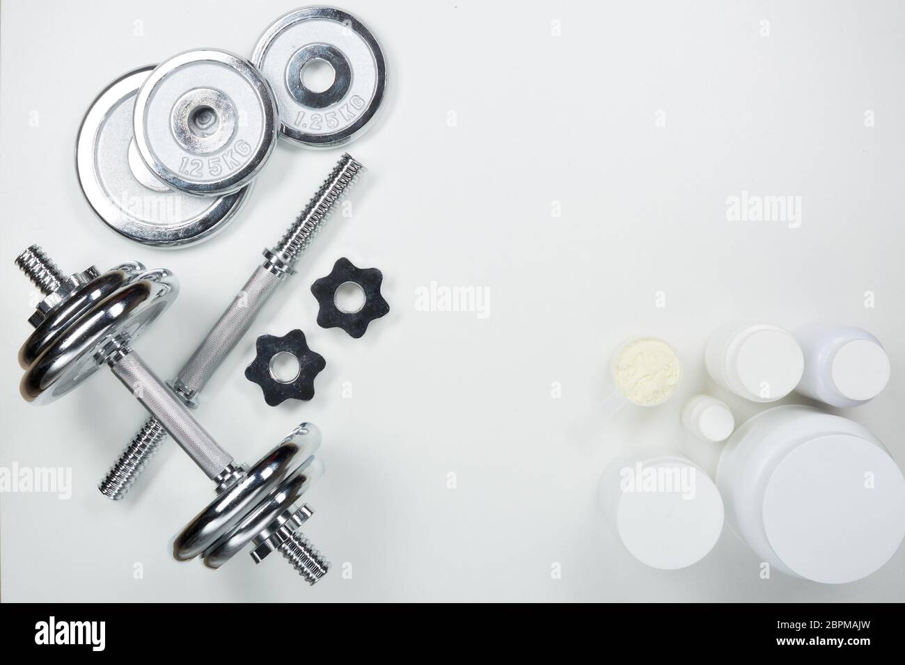 Sports nutrition (supplements), and dumbbells on a white background ...