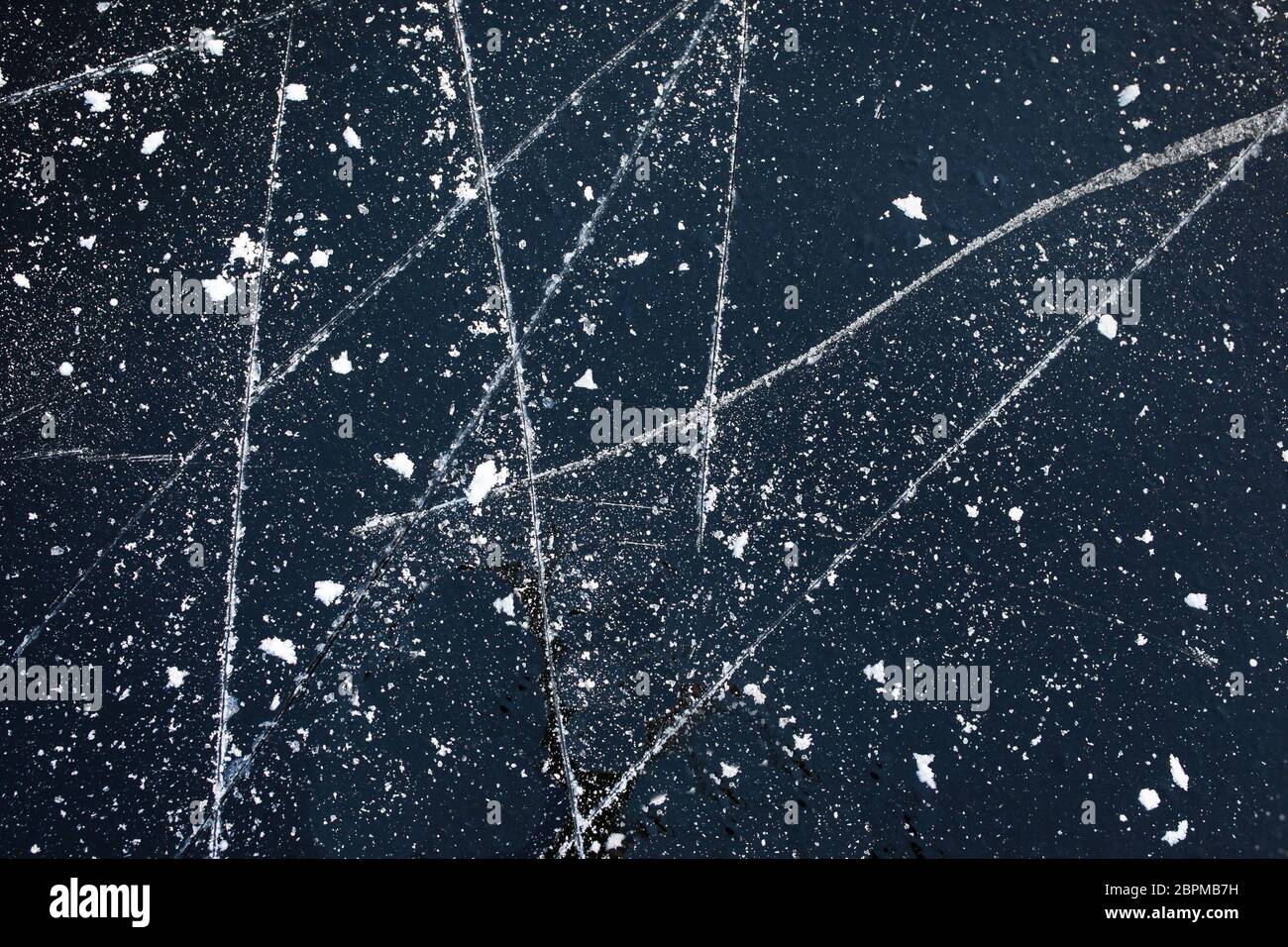 Surface of outdoor ice with snow, replete with skate marks. close-up ...