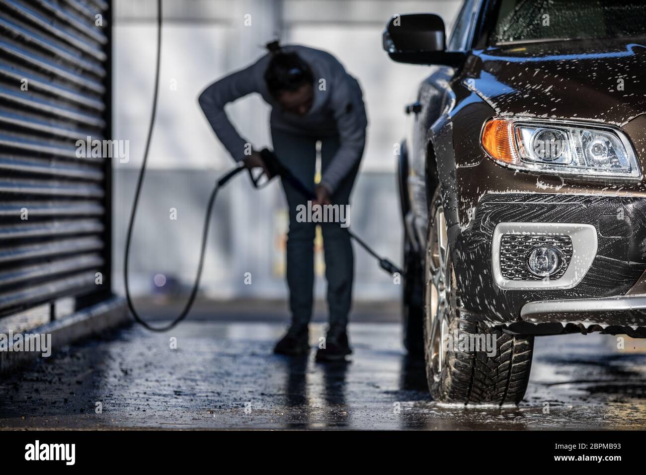 Cute woman washing her car in a manual carwash (color toned image Stock ...