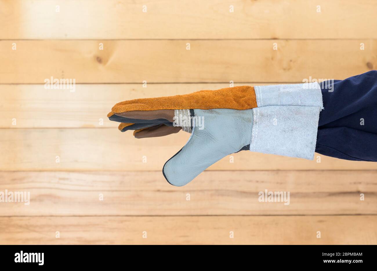Working hand in Rough leather glove with wall wood background Stock ...