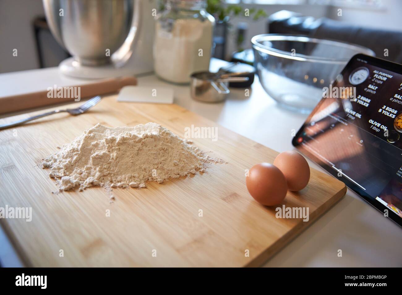 Still life of baking equipment and digital tablet with recipe on screen ...