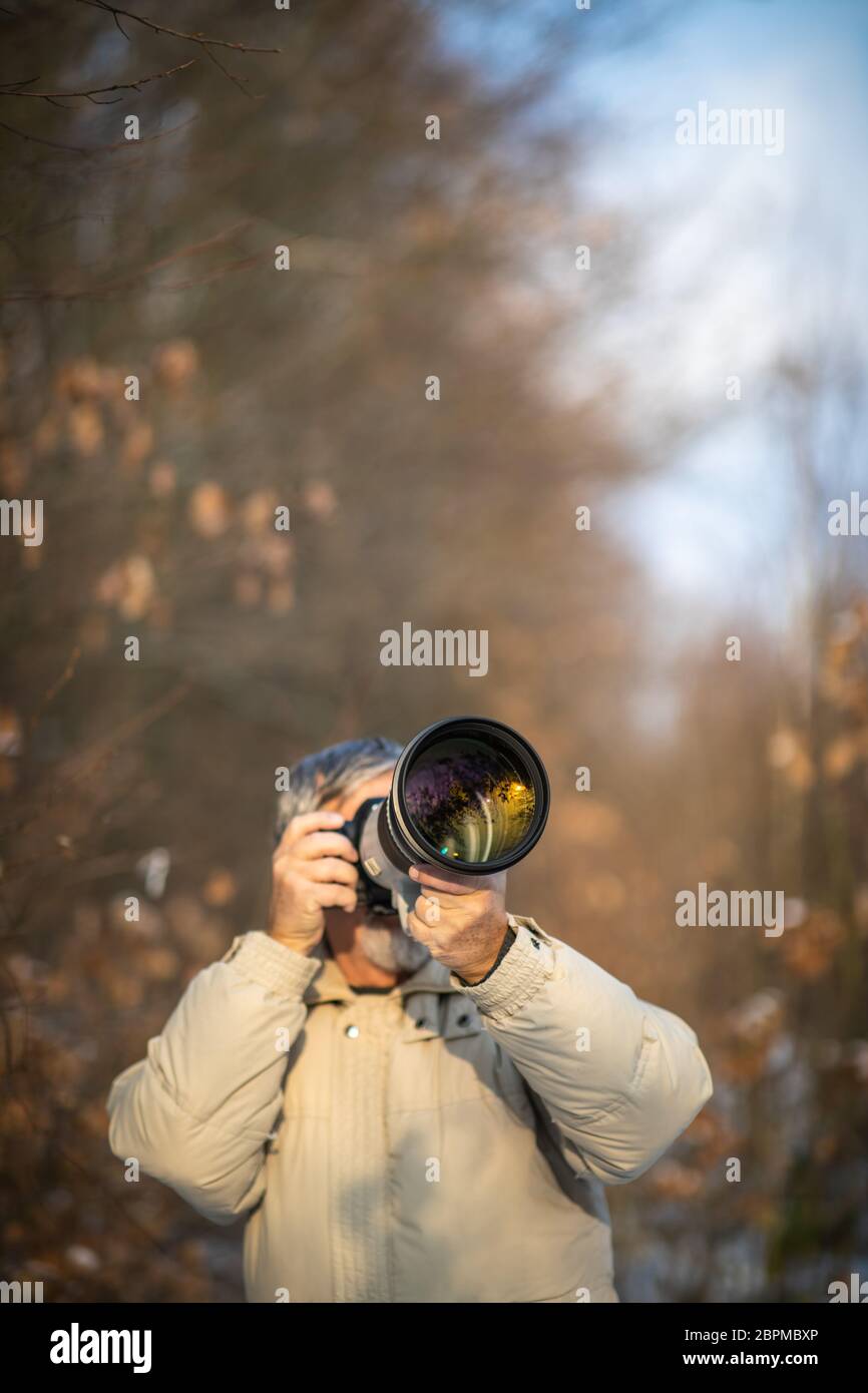 Senior man devoting time to his favorite hobby - photography - taking ...