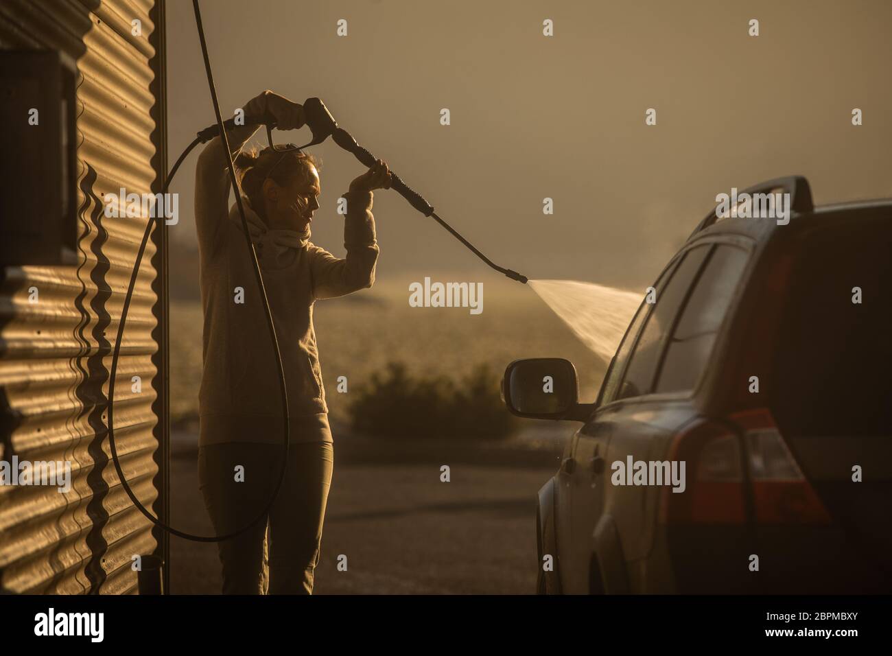 Cute woman washing her car in a manual carwash (color toned image Stock ...