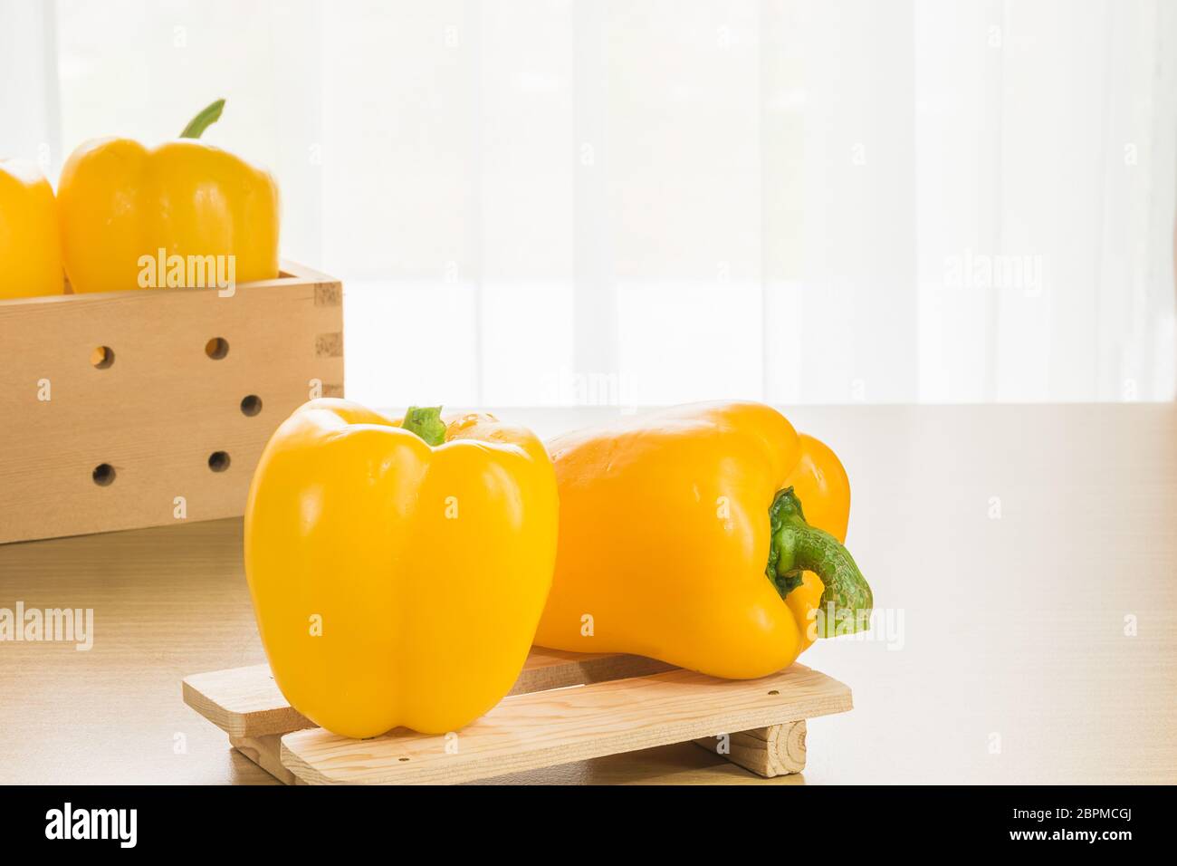 Fresh yellow bell peppers (capsicum) in wood box Stock Photo - Alamy