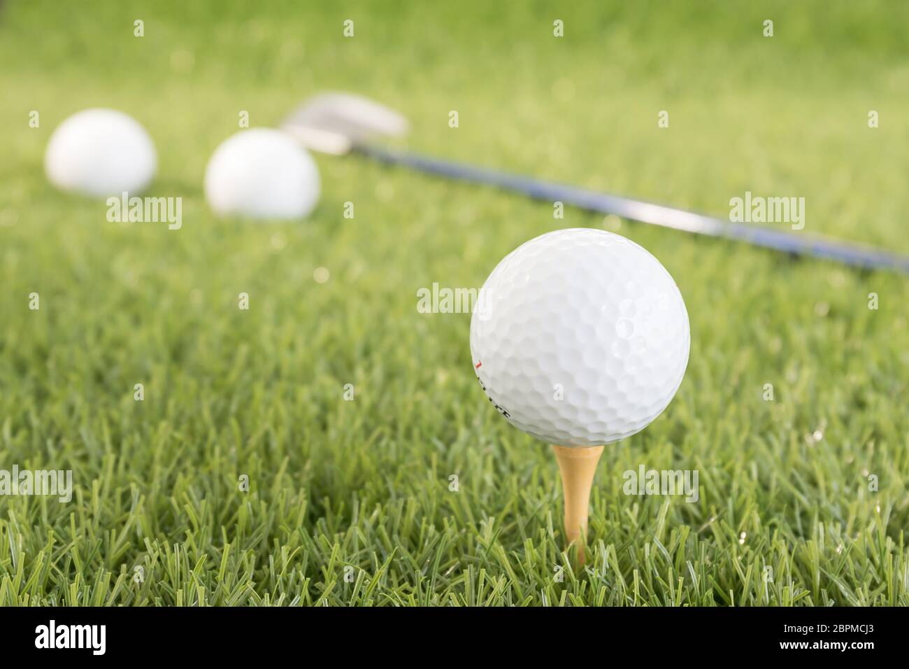Golf ball sitting on tee putting in golf course. Golf ball on tee ready ...