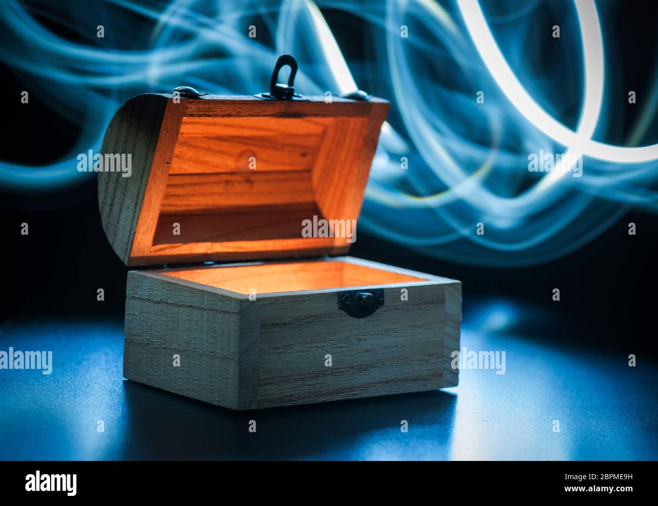 Small wooden chest inside illuminates on a blue background with ...